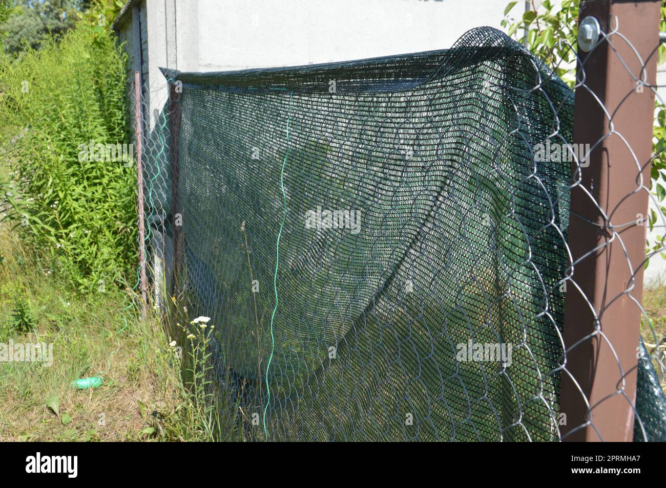 Installation of a shading net on a the chain-link fence Stock Photo - Alamy