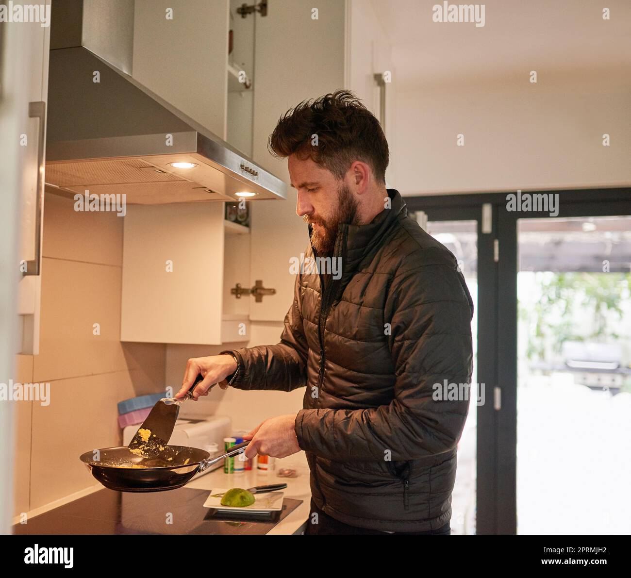 Home for the weekend. a young man cooking at home Stock Photo - Alamy