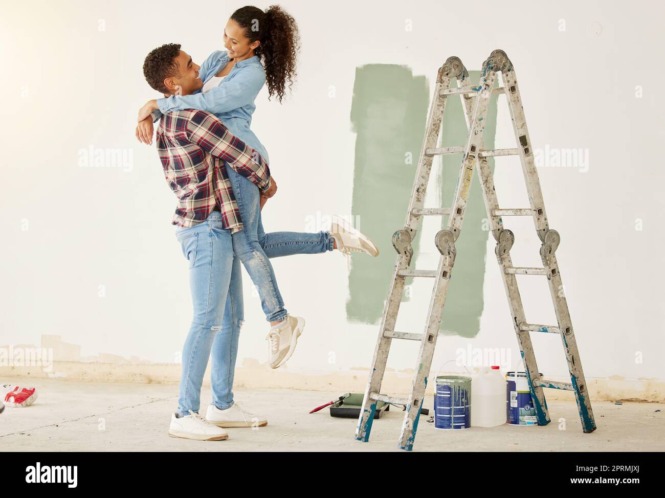 Love couple smile painting house or home interior with paint and ladder for DIY room project and ...