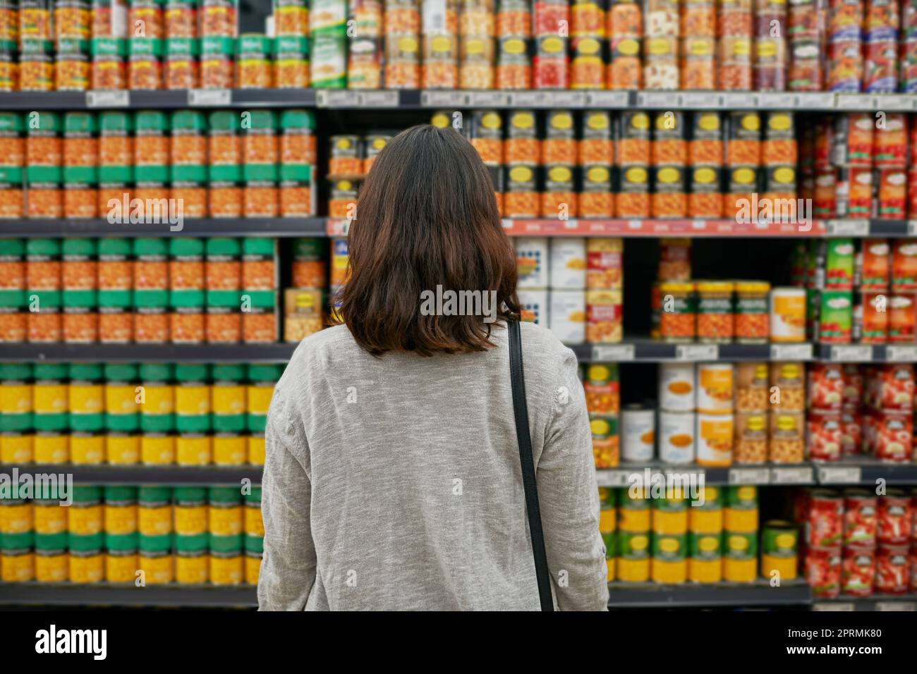 Woman comparing prices in supermarket hi-res stock photography and ...