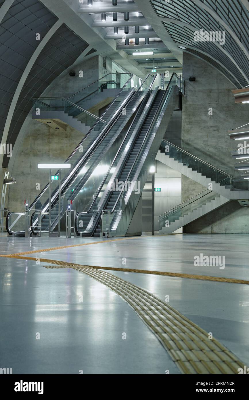 Futuristic subway station with guiding lines and an escalator near ...