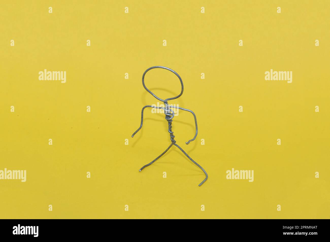 Metal man made of wire stands on the yellow background Stock Photo - Alamy