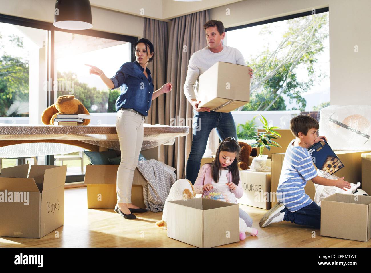 It goes quicker when we unpack together. a young family unpacking boxes ...