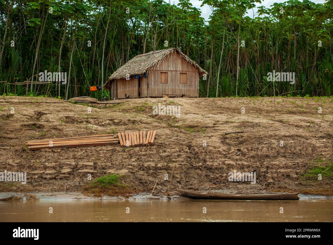 Hut on riverbank with canoe, Amazon Stock Photo - Alamy