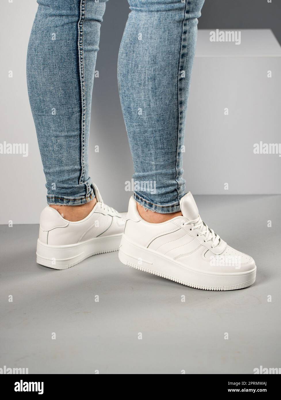 Cropped image of side view of female model of sports shoes on studio ...