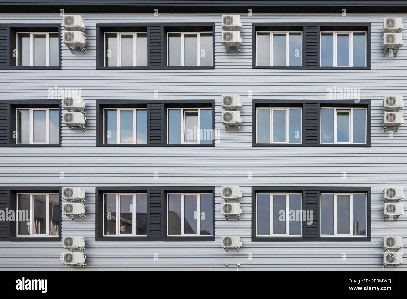 Many air conditioners hang on facade of new modern building Stock Photo ...