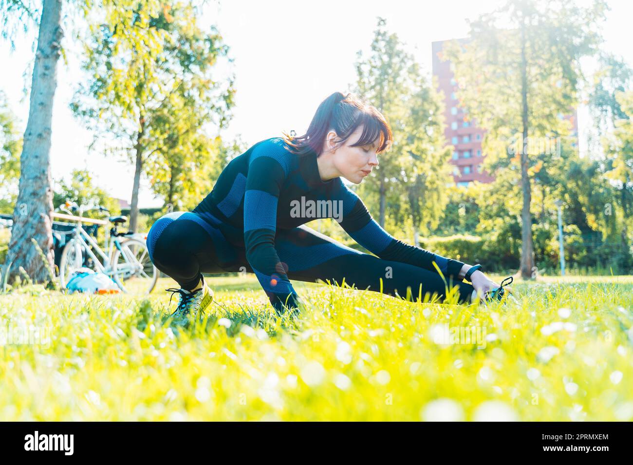 Woman does gym stretching exercises outdoor under the sun Stock Photo ...