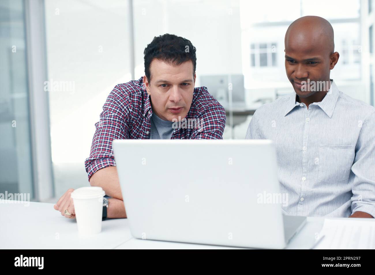 Reviewing a few designs. Two designers working on a project on a laptop ...