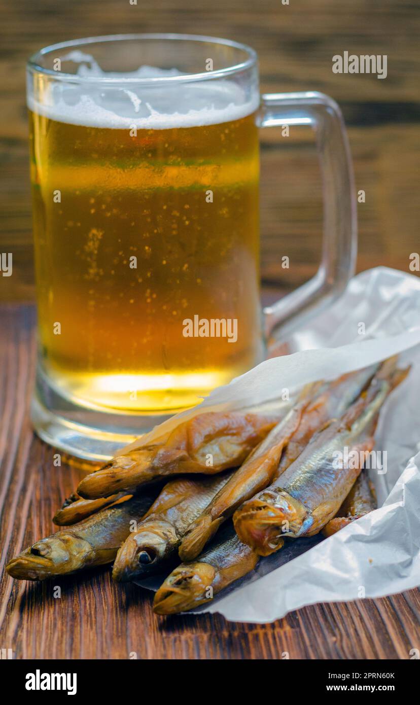 Smoked, salted fish for beer on paper with a glass of beer Stock Photo ...