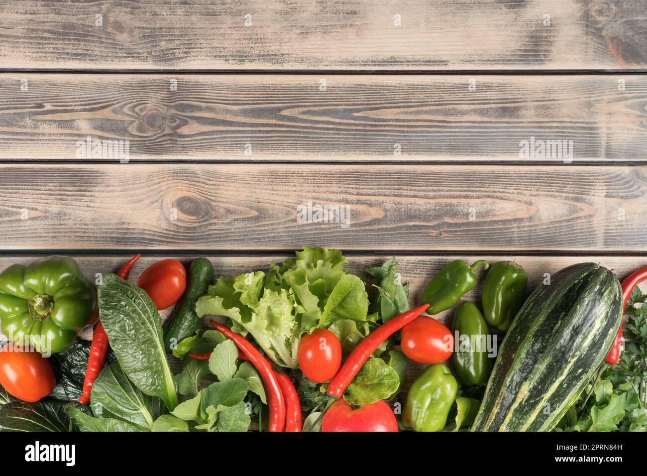 Horizontal row of fresh farm vegetables on wooden table, top view ...