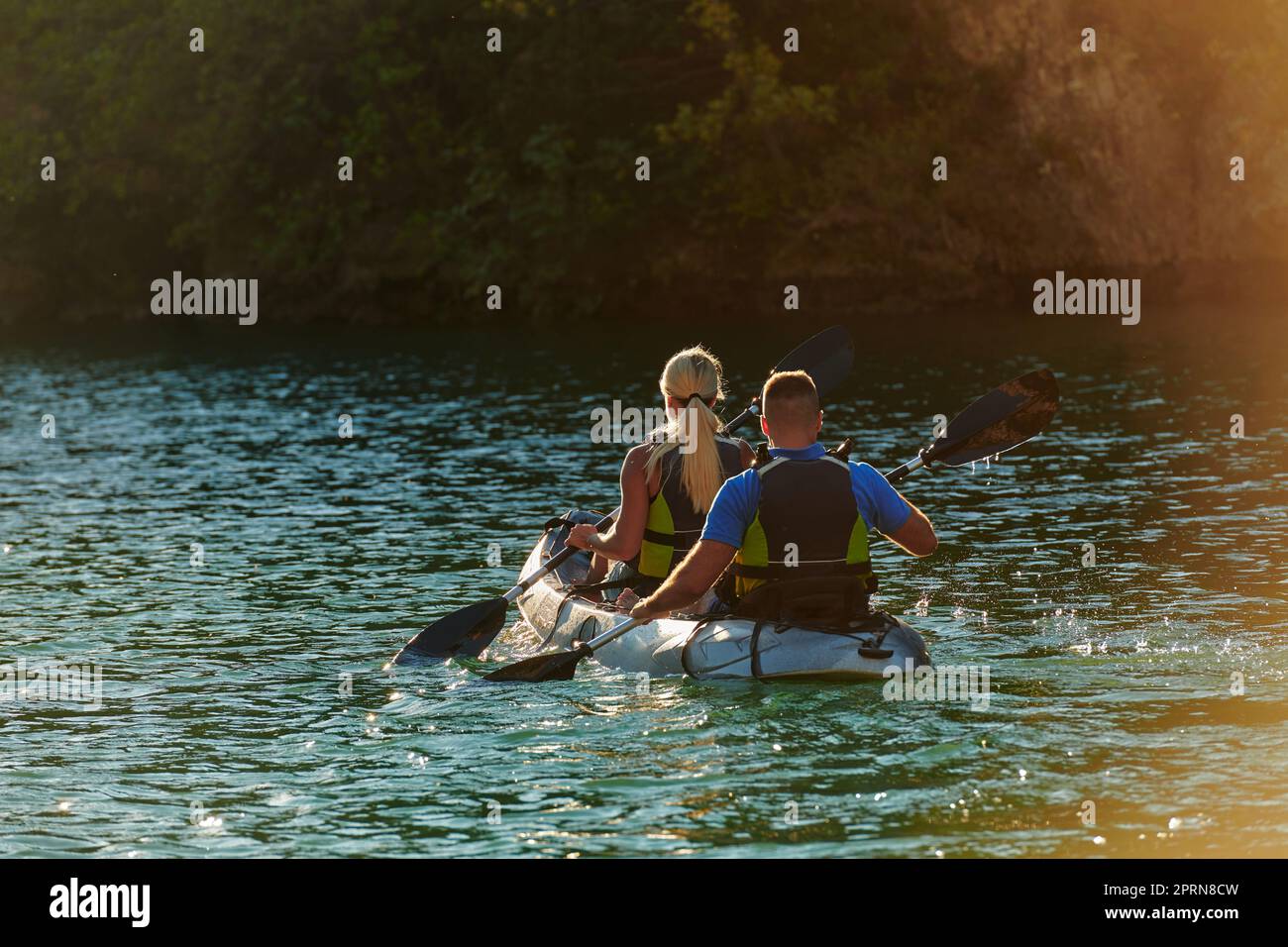 A young couple enjoying an idyllic kayak ride in the middle of a ...