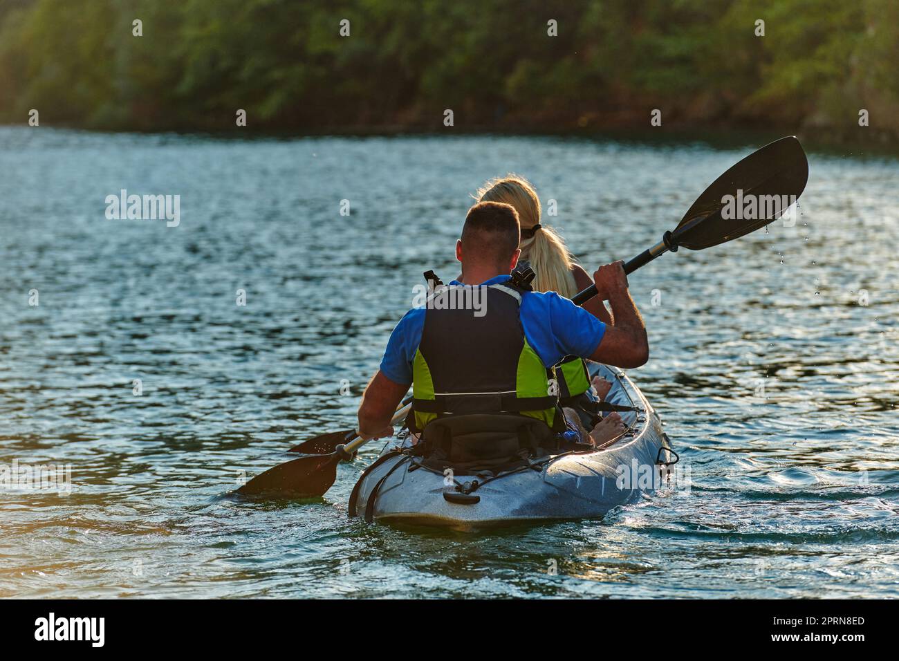 A young couple enjoying an idyllic kayak ride in the middle of a ...