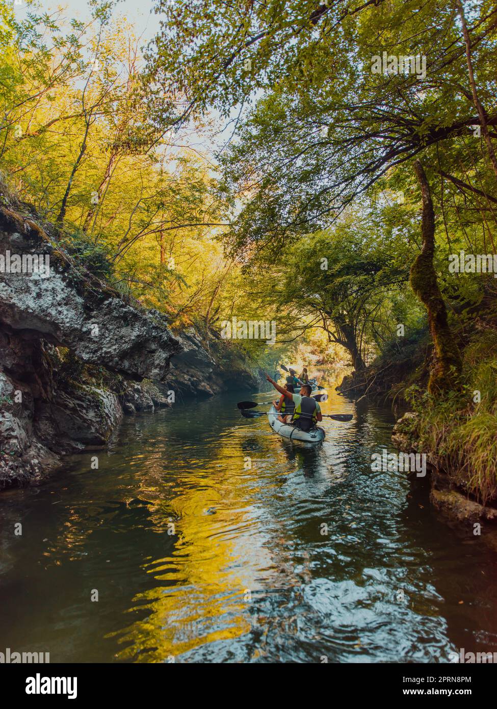 A young couple enjoying an idyllic kayak ride in the middle of a ...