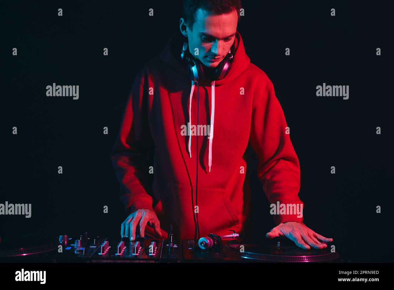 Hip hop DJ in red hoodie coat scratching vinyl record on a turntable ...