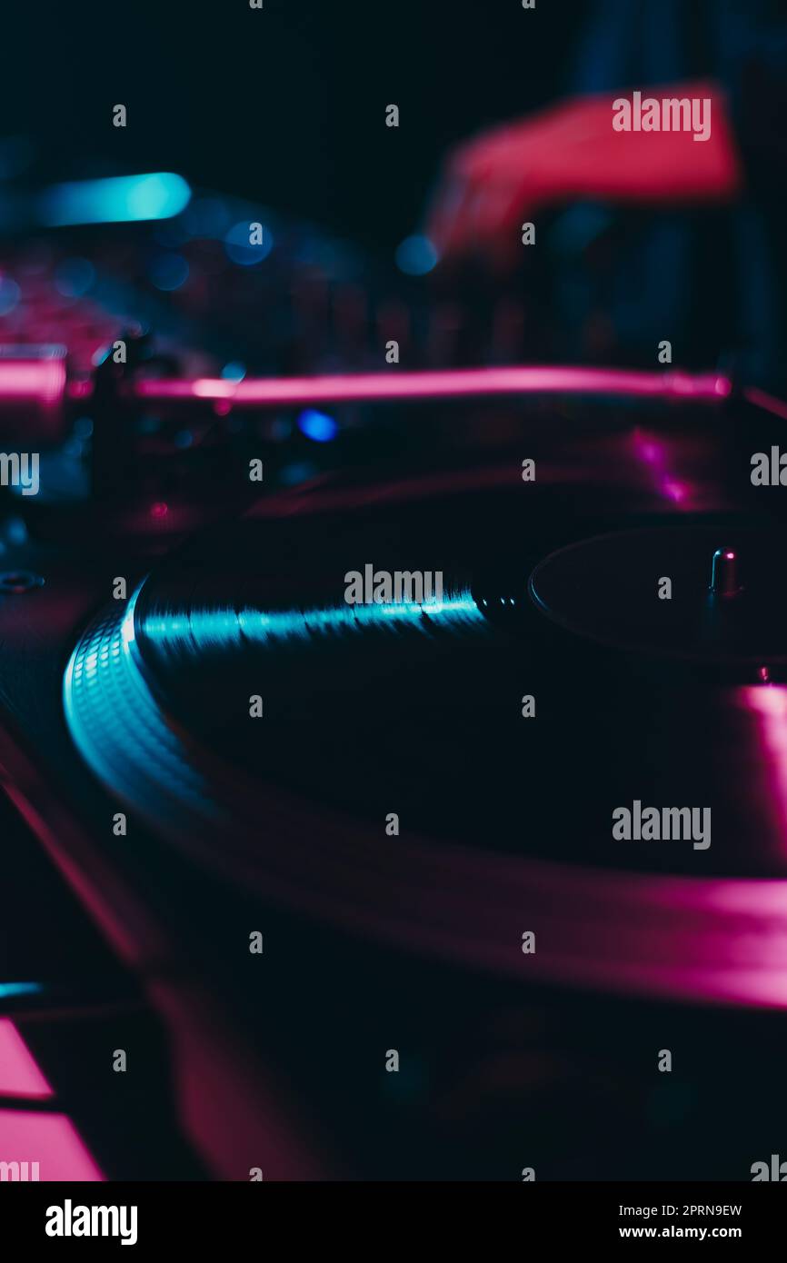 Turntable playing vinyl record on a party in dark night club. Techno DJ ...