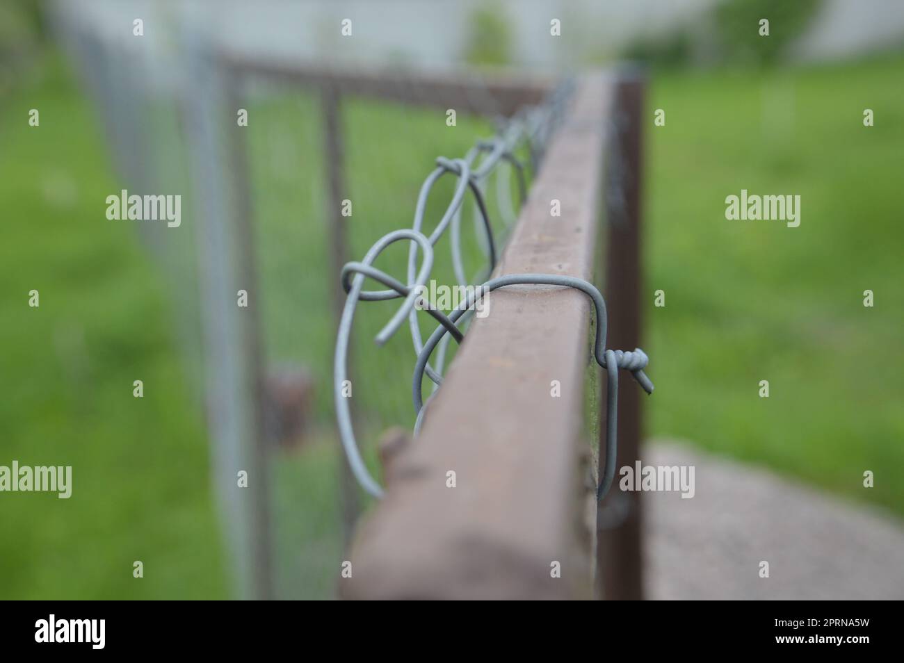 Tensioning and securing a mesh fence with a the metal wire netting ...