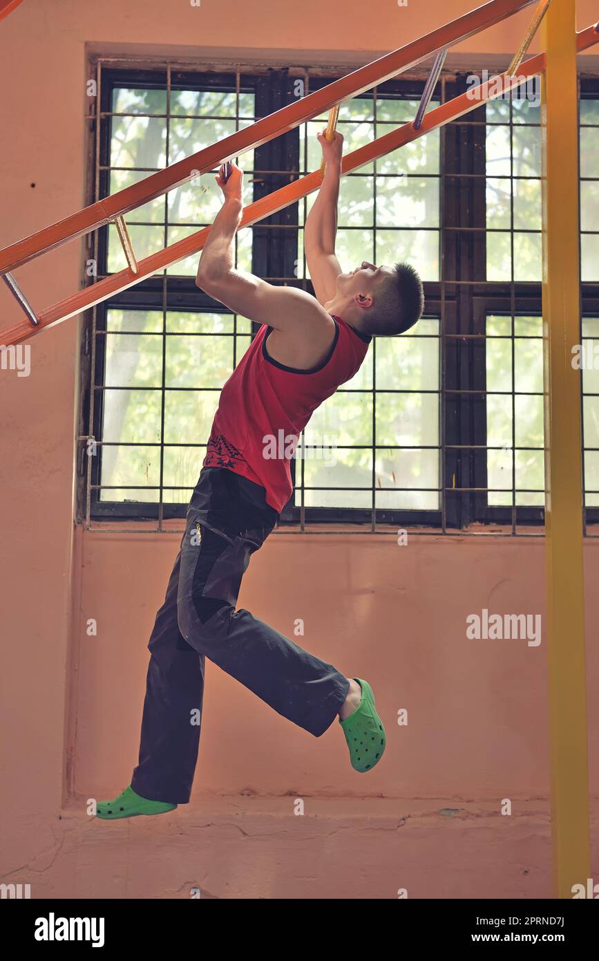 Athlete man working out arms swinging on brachiation ladder Stock Photo ...