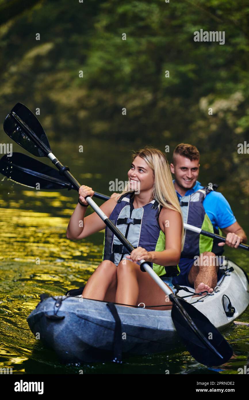 A young couple enjoying an idyllic kayak ride in the middle of a ...