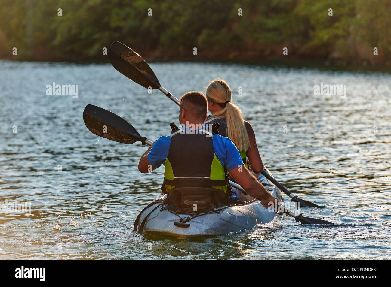A young couple enjoying an idyllic kayak ride in the middle of a ...