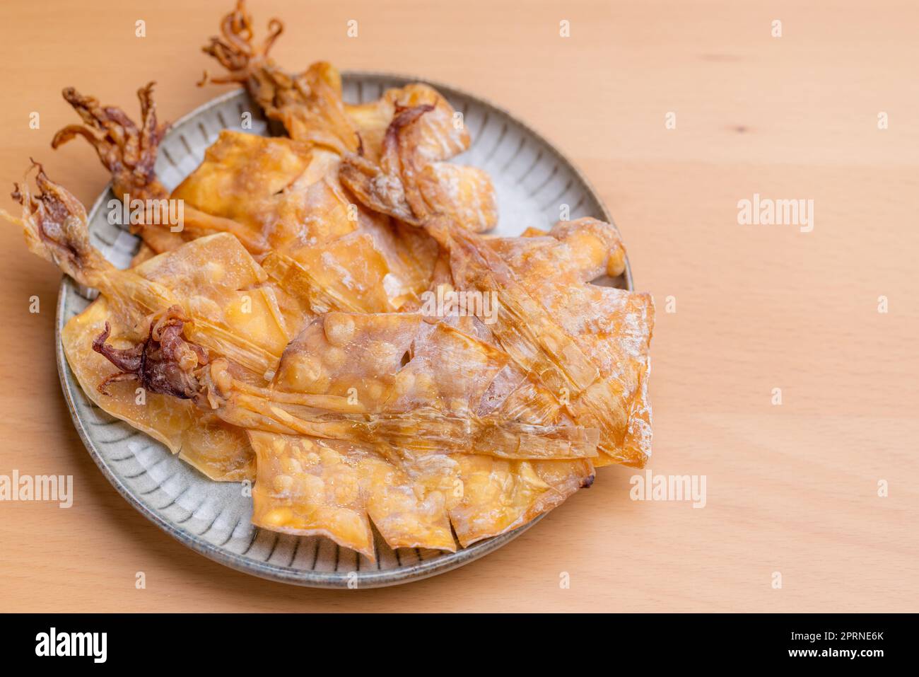 Dried squid snack in the plate Stock Photo - Alamy