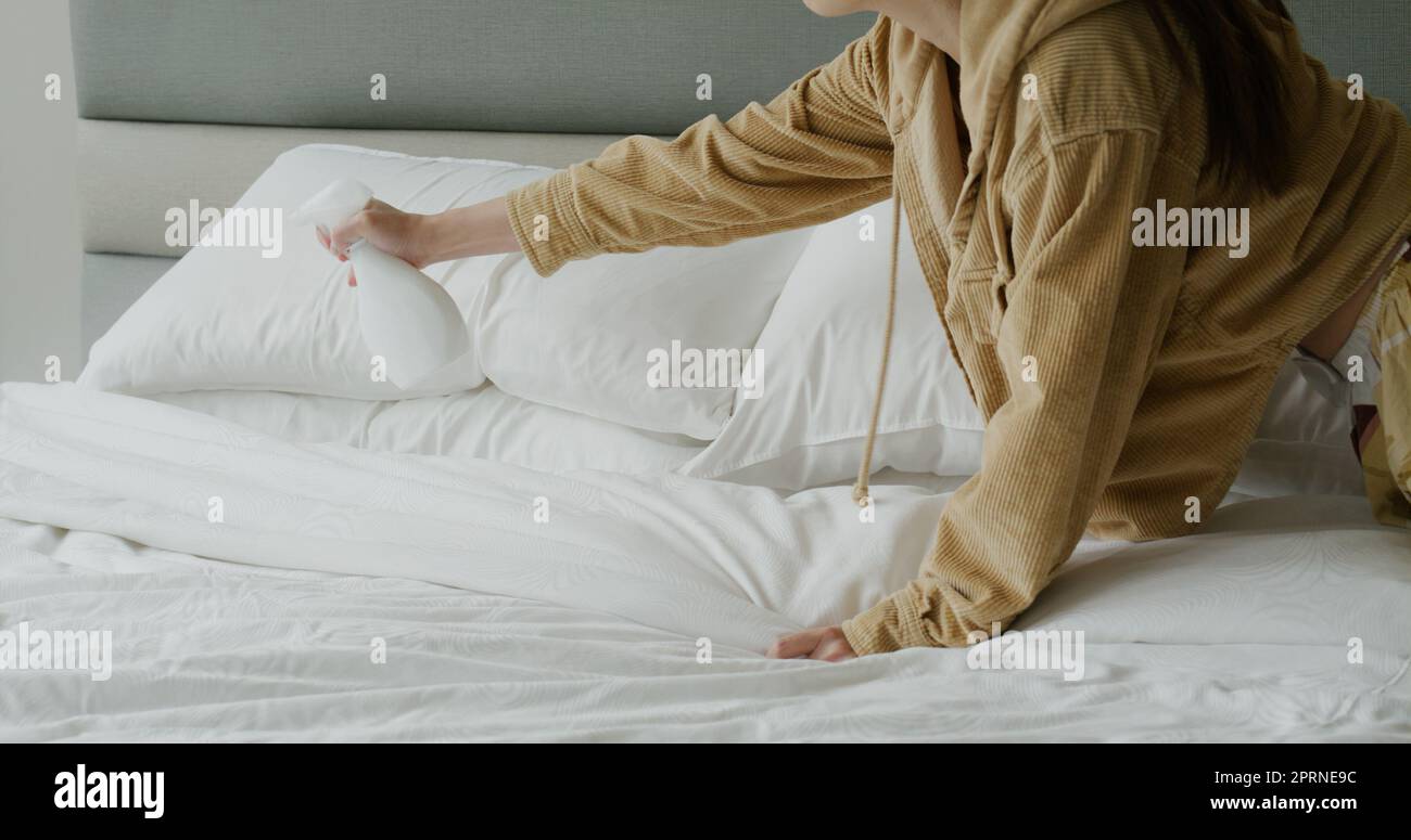 Housewife use disinfection alcohol spray on her bed at home Stock Photo ...