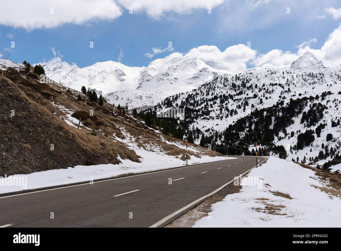 A highway winding through a winter landscape with snow-capped rocks and ...