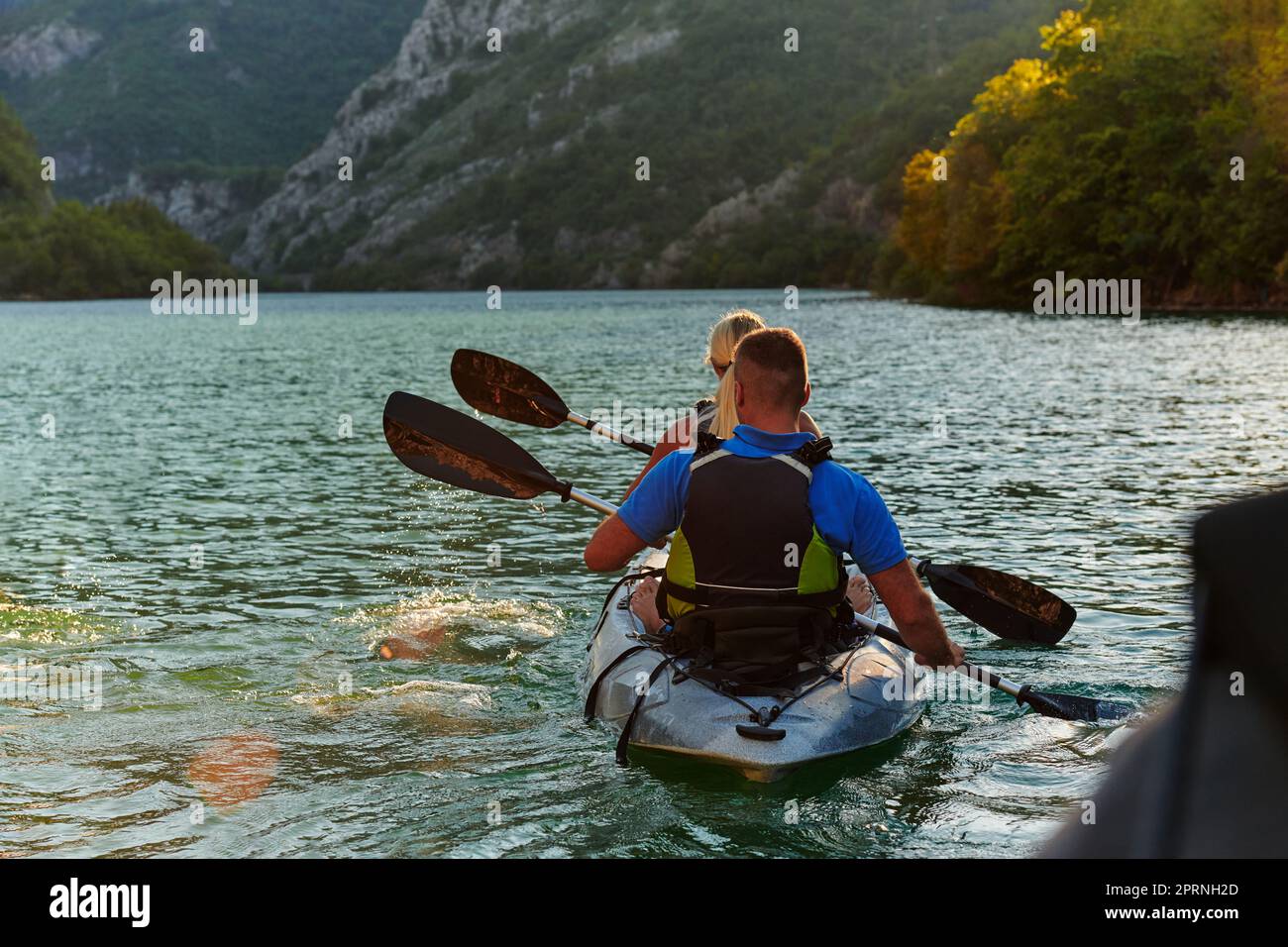 A young couple enjoying an idyllic kayak ride in the middle of a ...