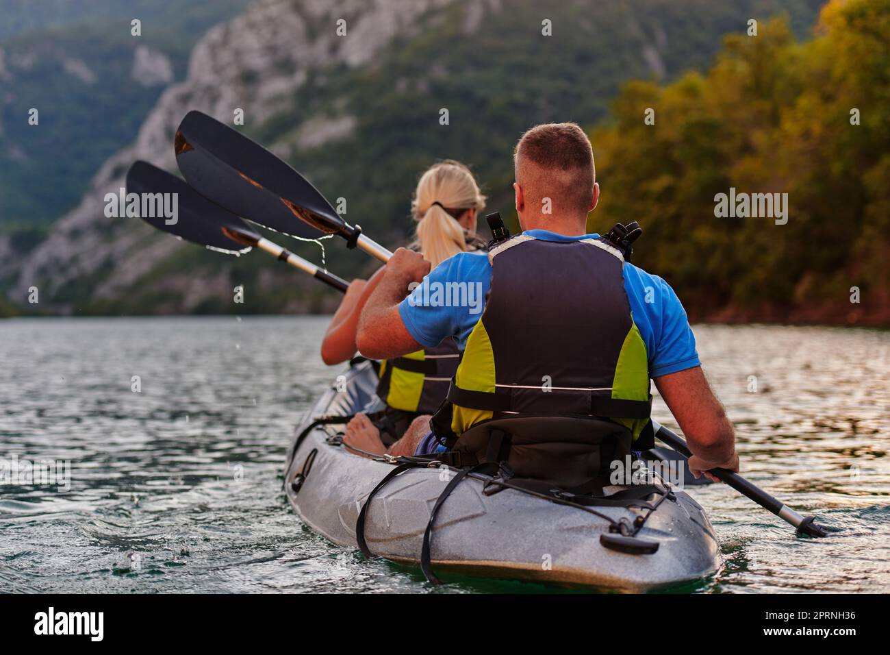 A young couple enjoying an idyllic kayak ride in the middle of a ...