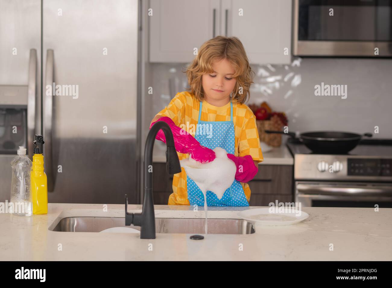 Dish washing concept. Cute kid help in washing dishes at kitchen. Kid ...