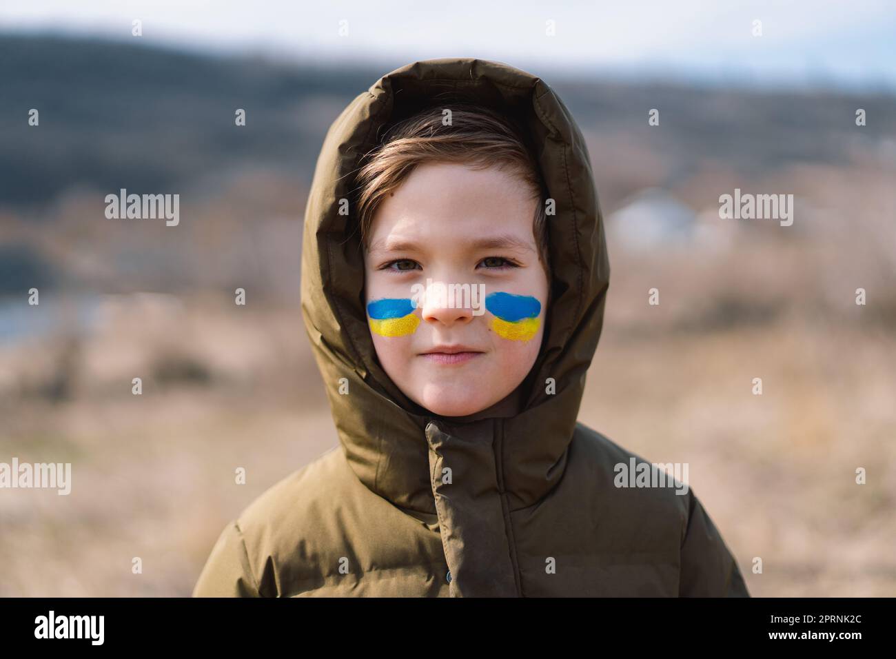 Portrait of a Ukrainian boy with a face painted with the colors of the ...