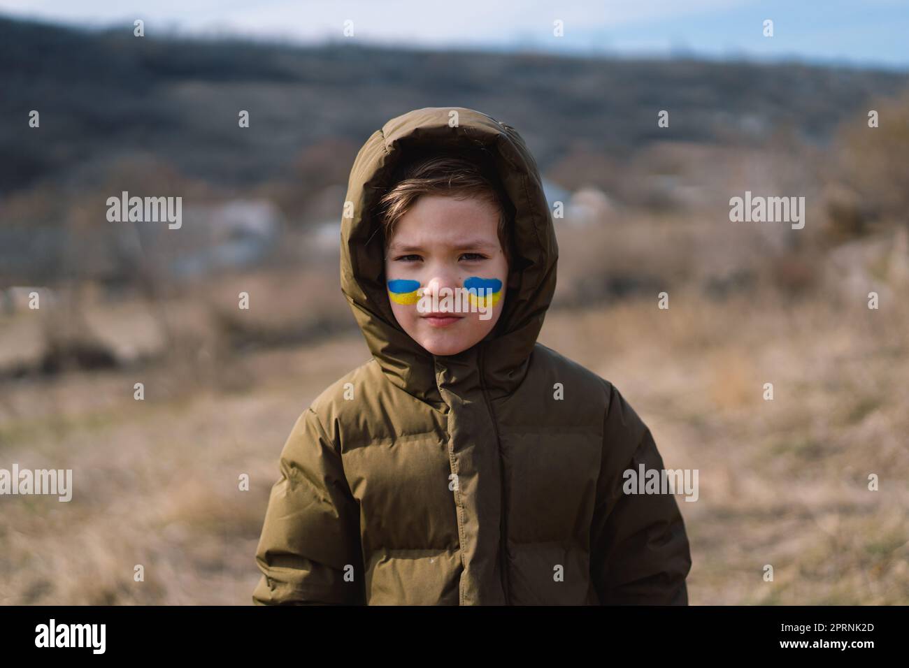 Portrait of a Ukrainian boy with a face painted with the colors of the ...