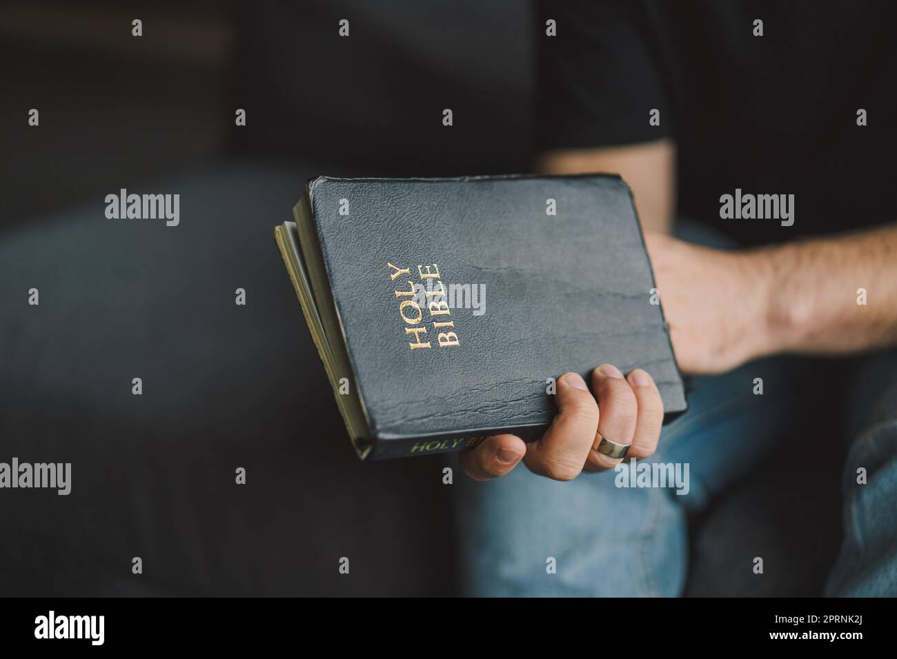 Christian man holds holy bible in hands. Reading the Holy Bible in a ...