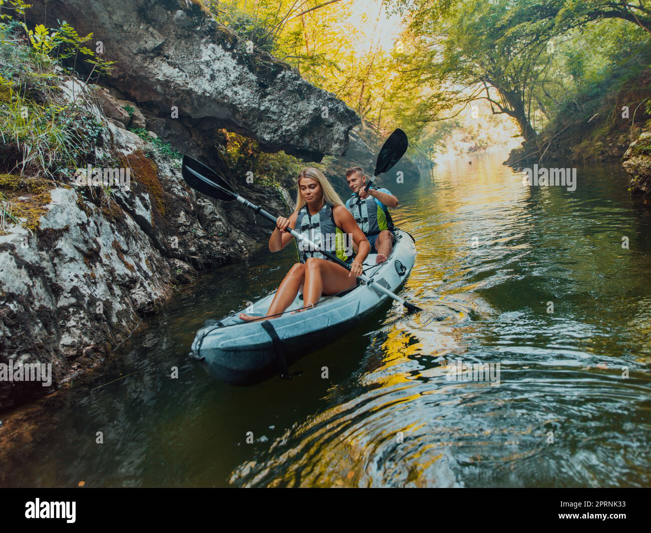 A young couple enjoying an idyllic kayak ride in the middle of a ...