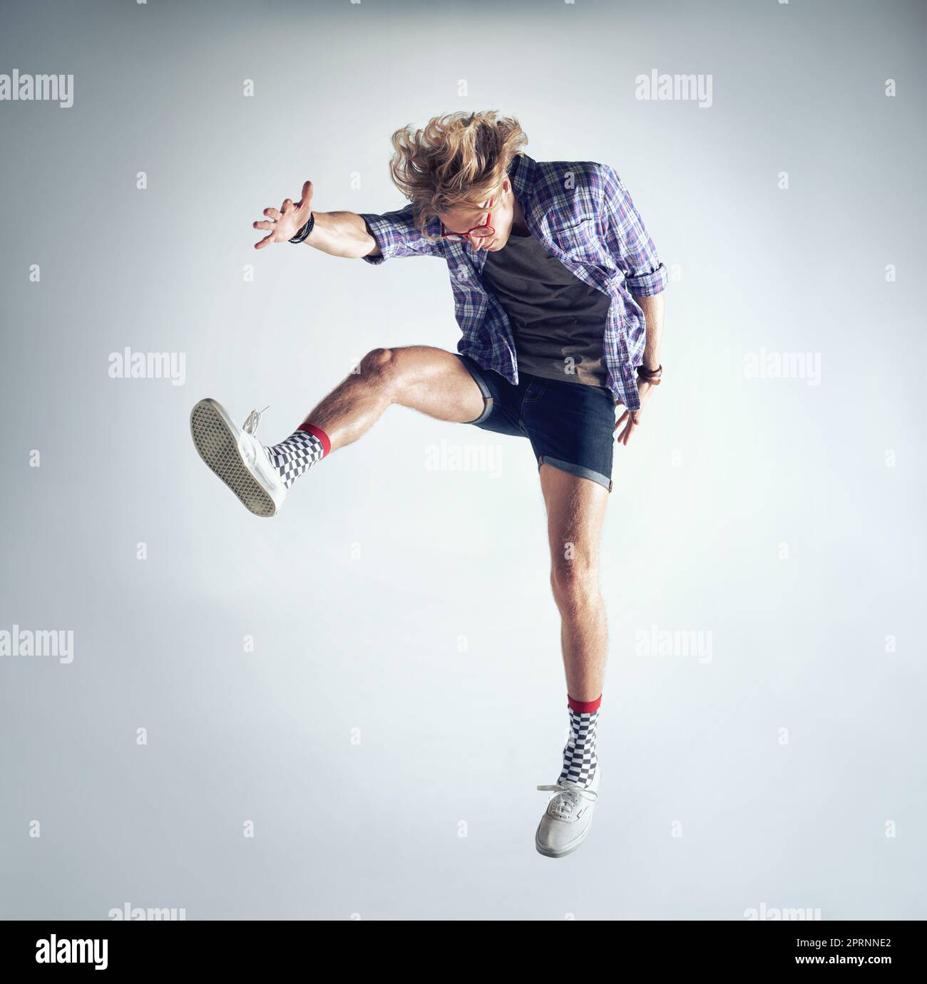 Crazy dance moves. A handsome young man dancing against a gray ...