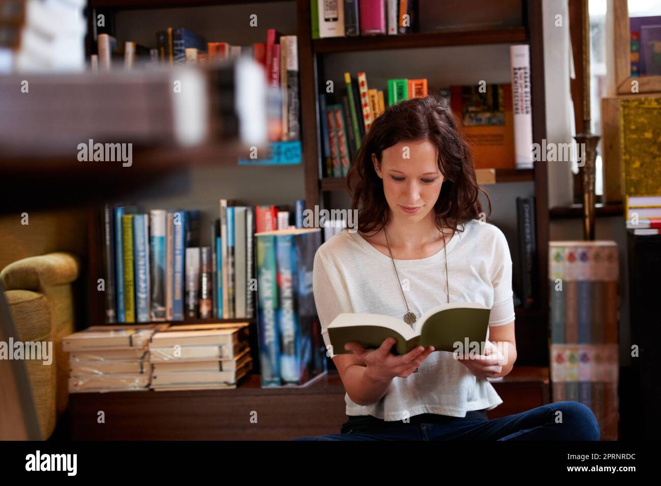 Whiling away the day with some reading. A young woman sitting on the ...