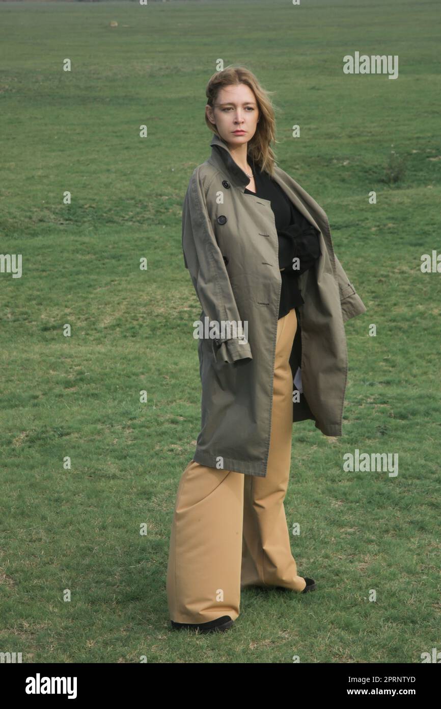 Outdoor Fashion Portrait Of Caucasian Woman In Wide Leg Beige Pants Black Blouse And Classic