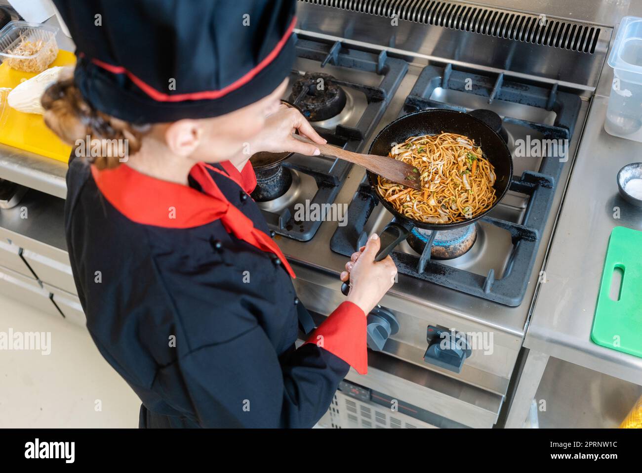 A female chef pouring cut onions on a vegetables in a pan Stock Photo ...