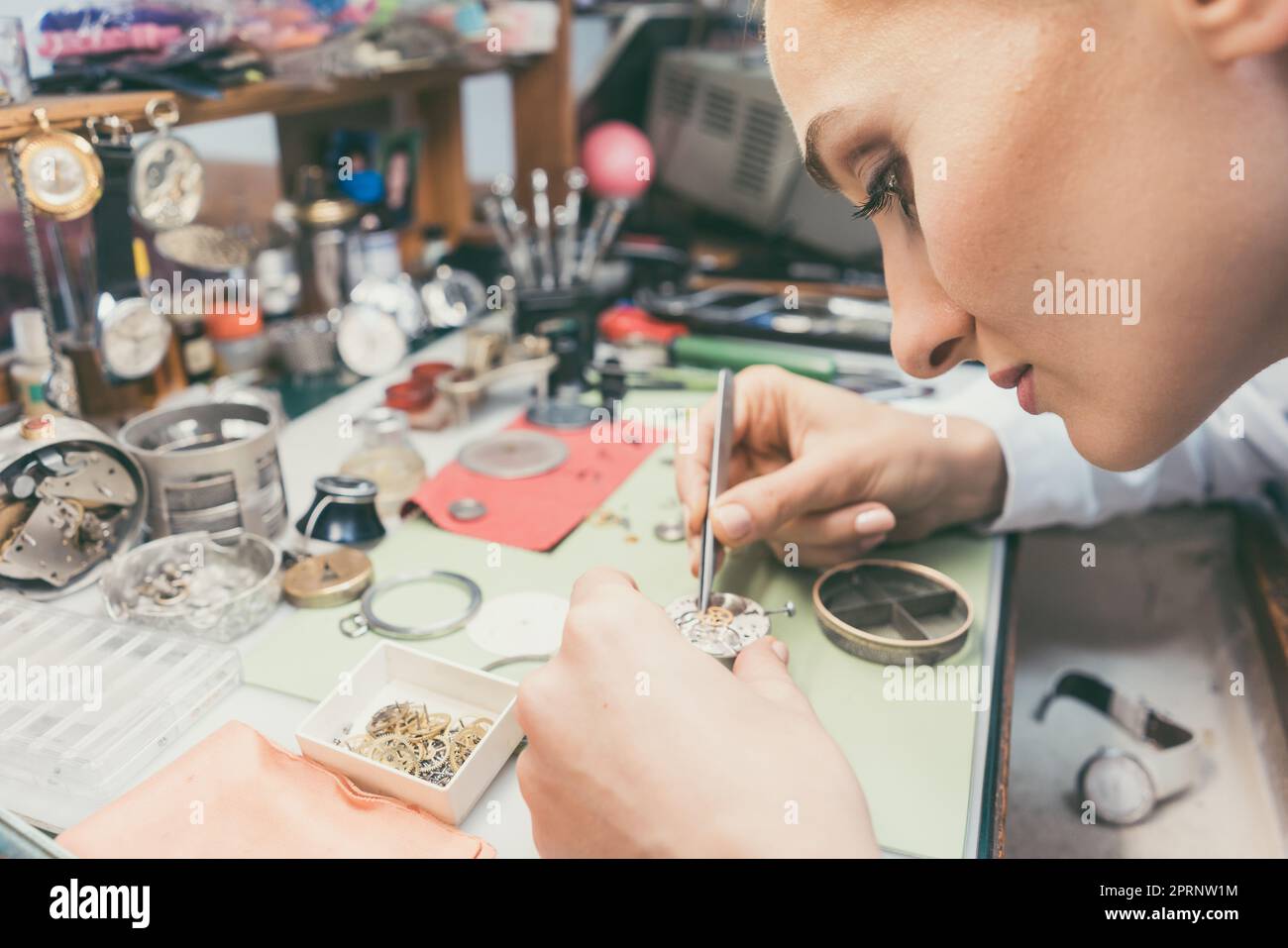 Diligent woman watchmaker working diligently on repairing a watch Stock ...