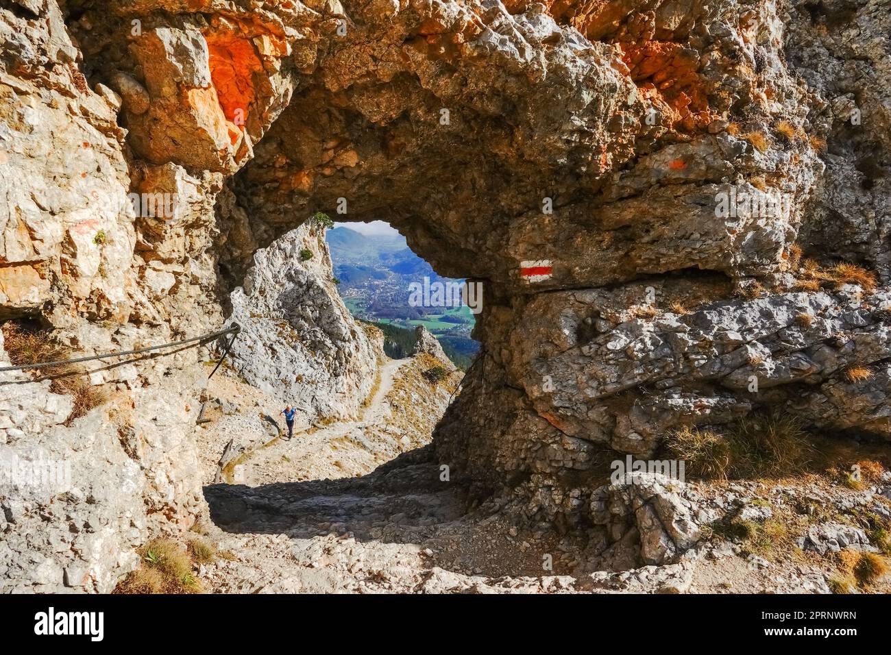 view through a round rocky passage with a sign from austria during ...