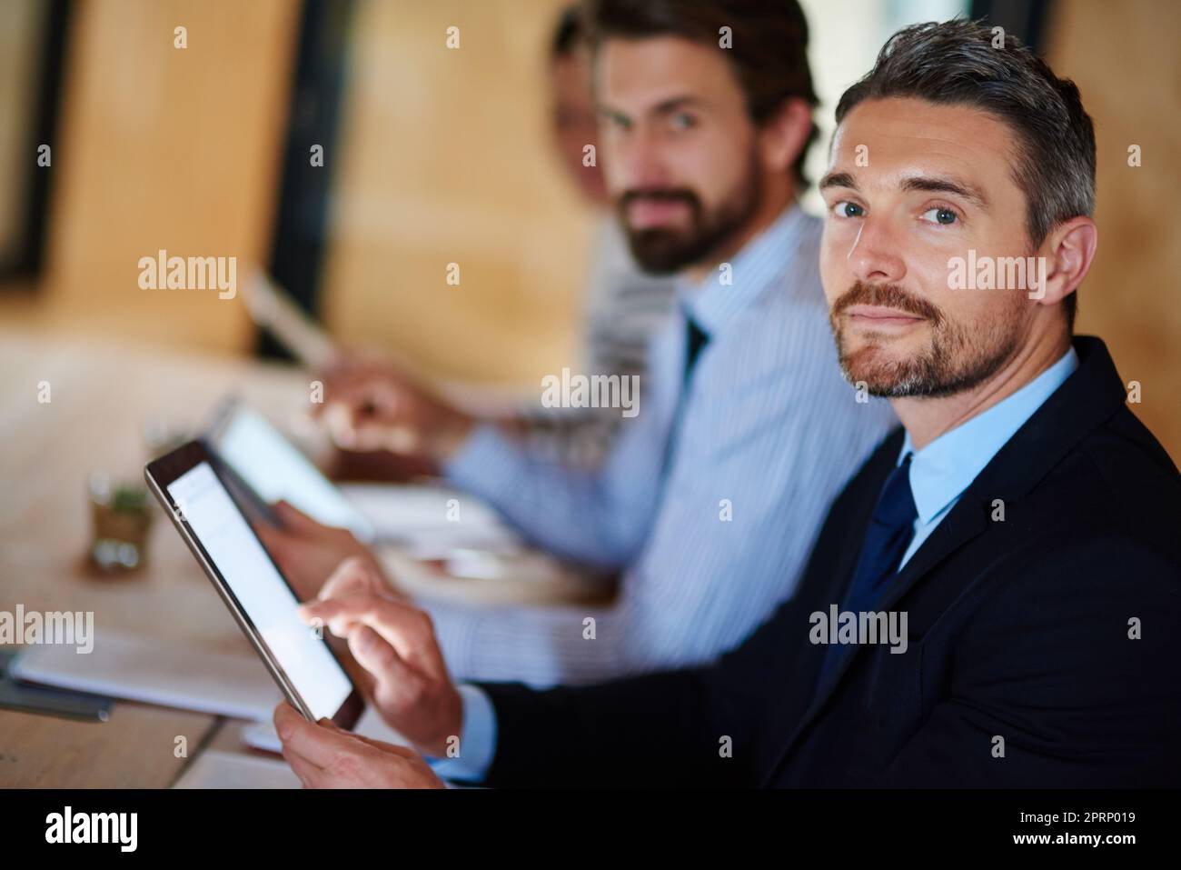 Tablets at the ready. Portrait of a businessman using a digital tablet ...