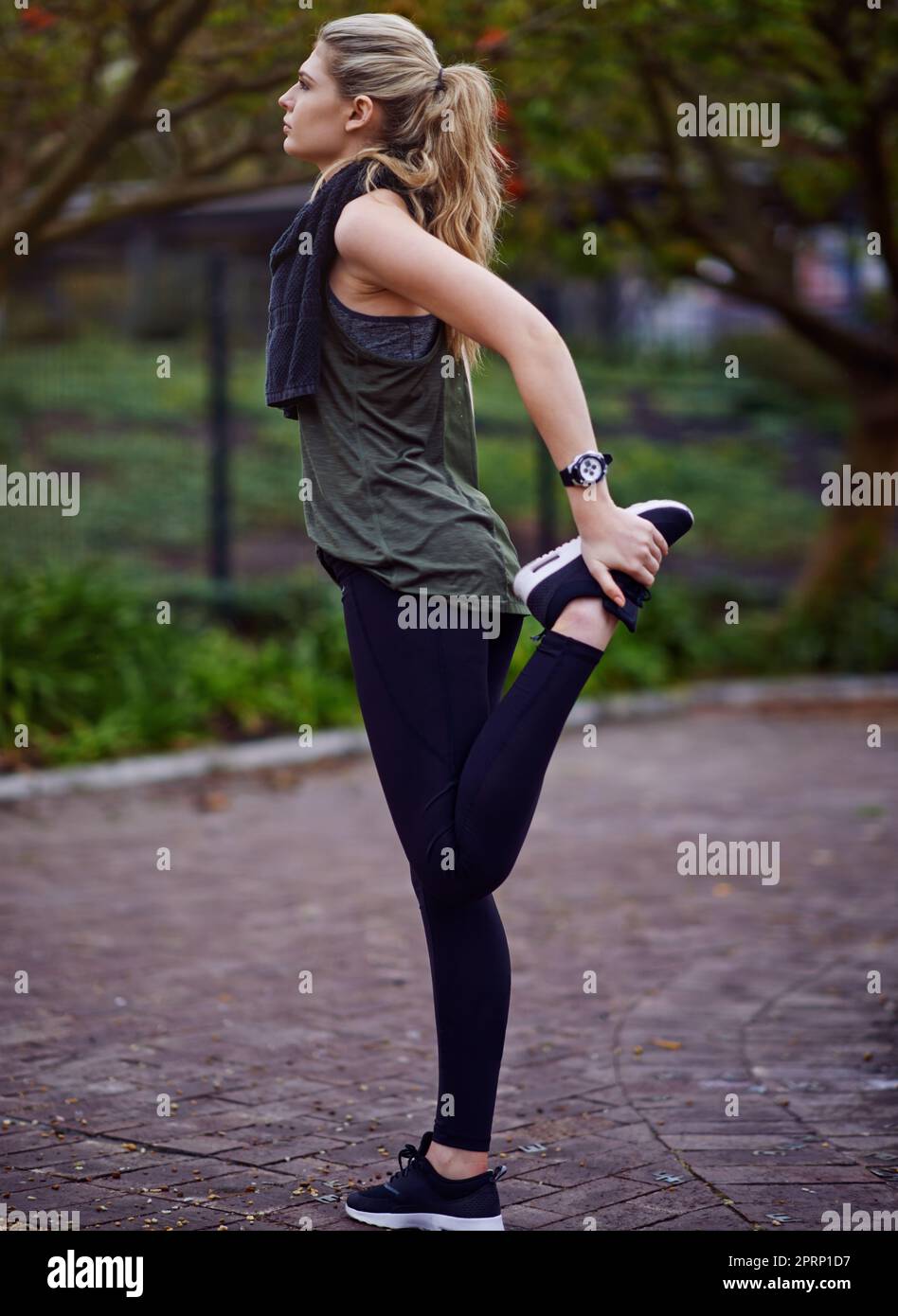 Stretching those muscles before hitting the road. a young woman ... Stretching those muscles before hitting the road. a young woman ...