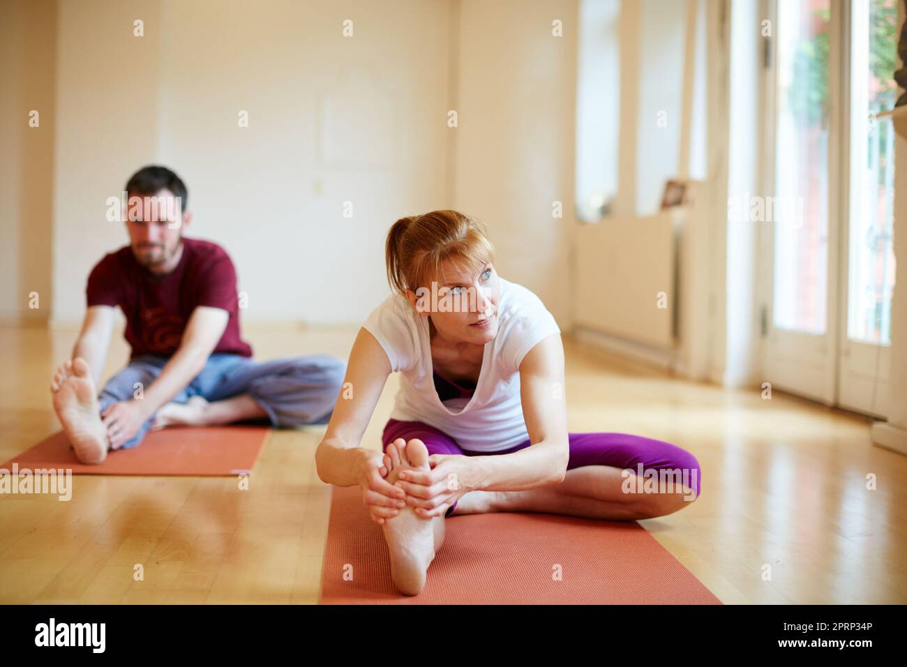 Staying relaxed and stress-free with yoga. two people doing yoga ...