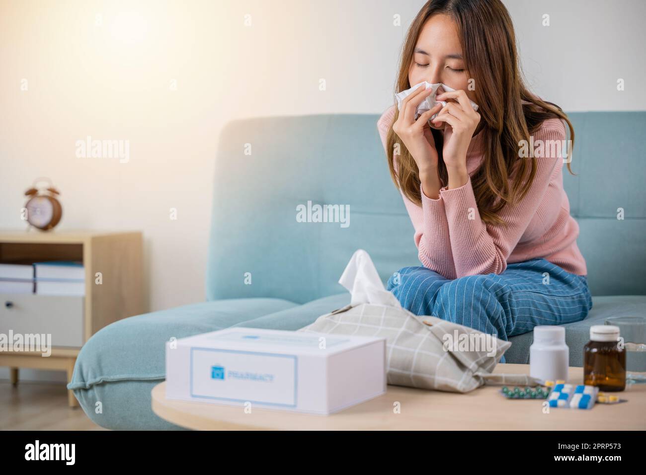 Asian young girl cold sick she sneeze with tissue paper on sofa Stock ...