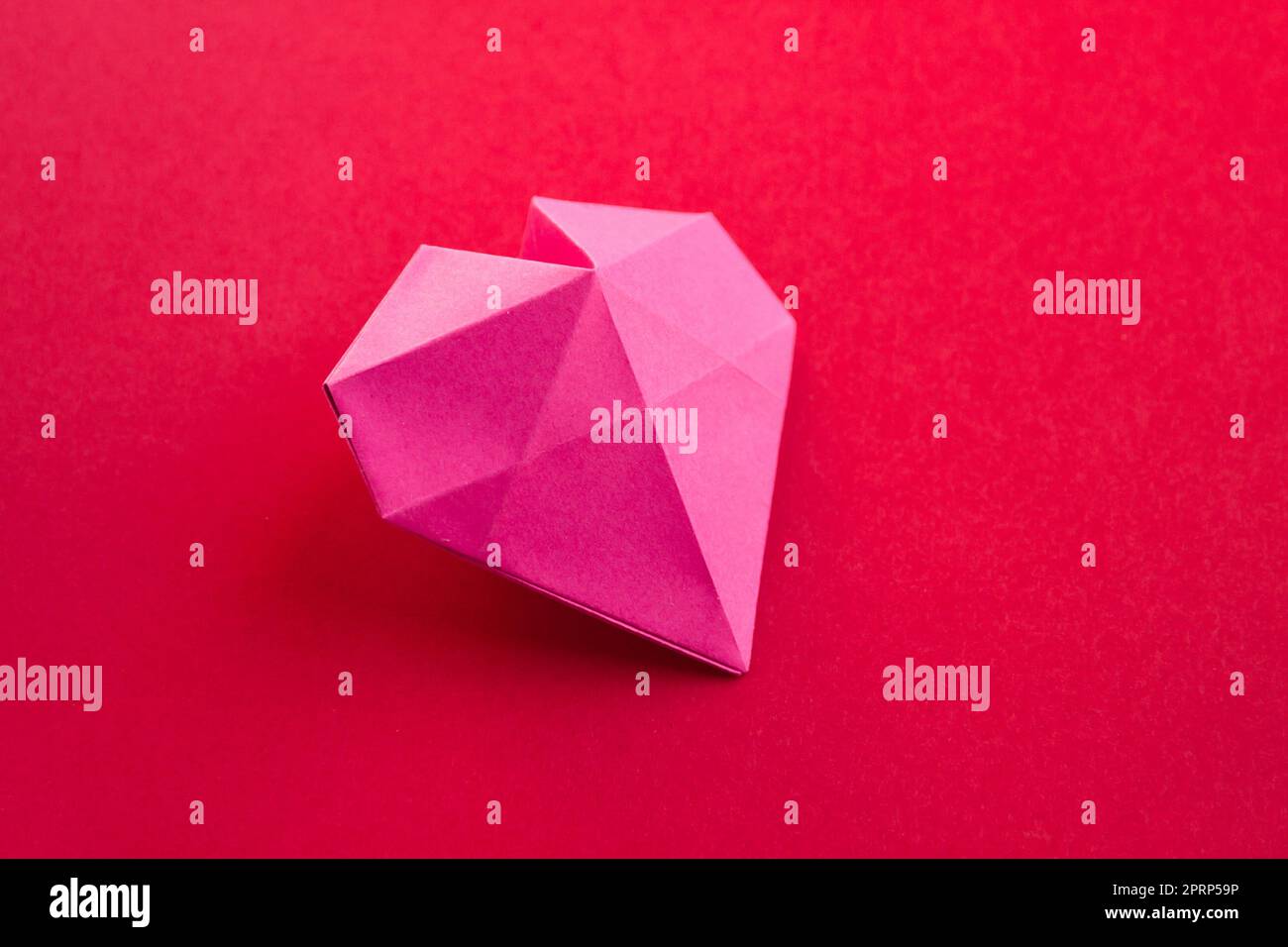 Pink paper heart origami isolated on a red background Stock Photo - Alamy