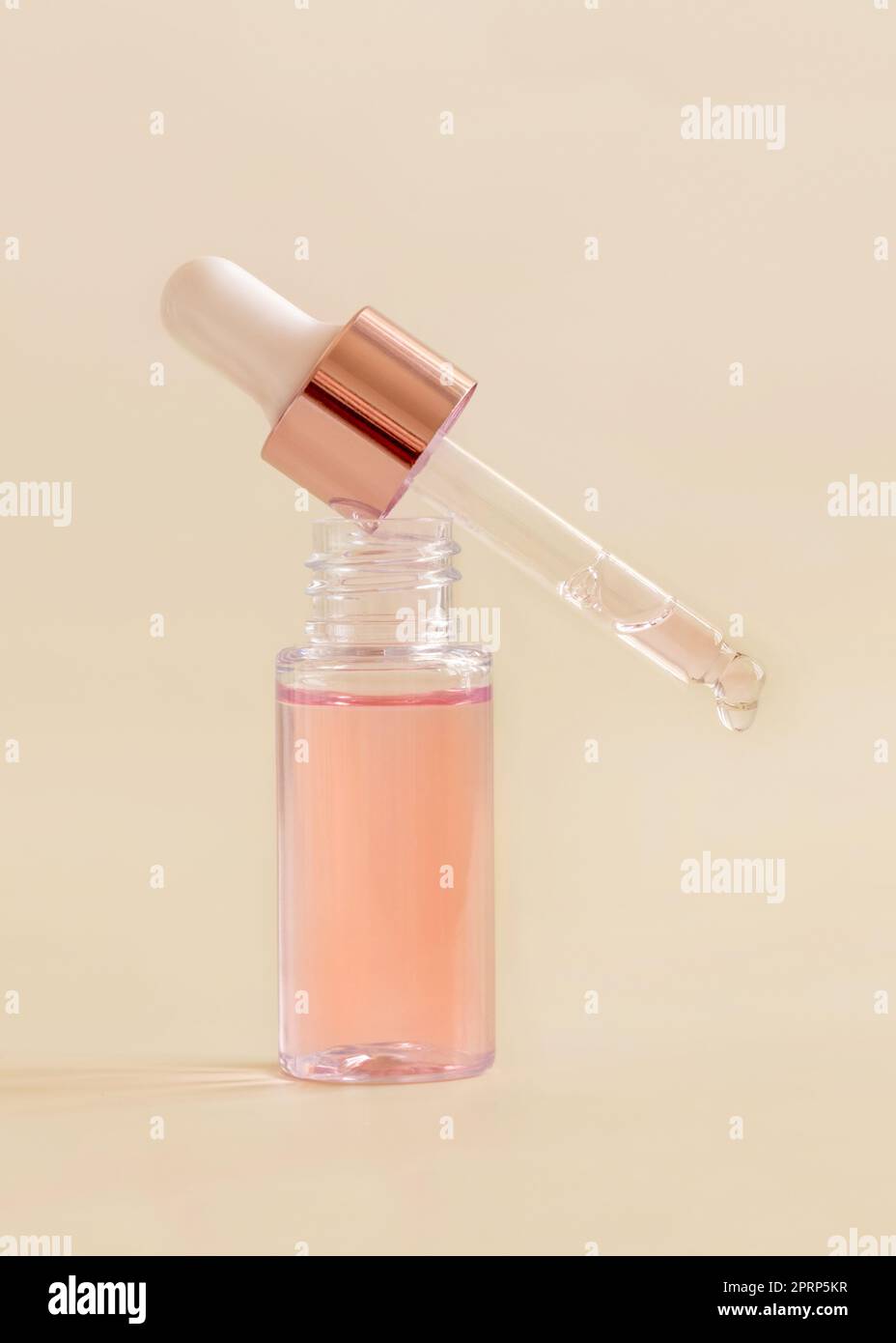 Opened Bottle with falling serum drop on light beige close up. Skincare ...
