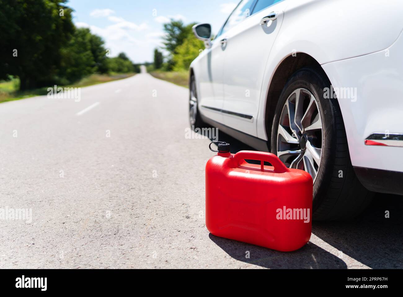 A car parked on the side of the road, an empty red canister. The driver ...