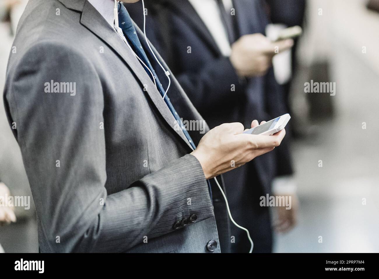Businessmen using their cell phones on Tokyo subway. Horizontal composition. Business travel and ...