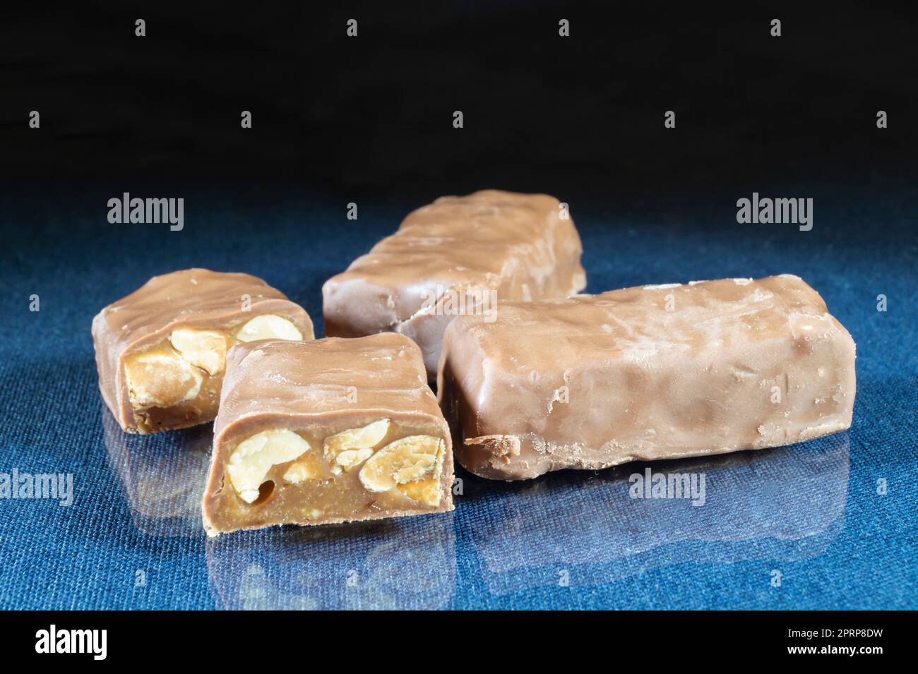 Sweet candy with nuts on the table with a reflection. Chocolates on a ...