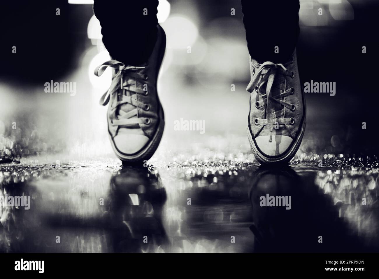 Twilight steps. Cropped image of a person wearing sneakers standing on ...