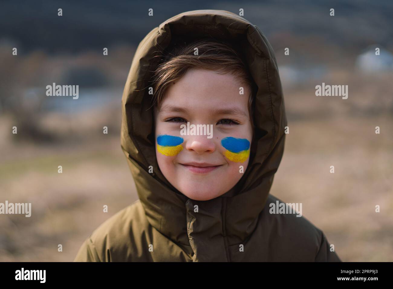 Portrait of a Ukrainian boy with a face painted with the colors of the ...